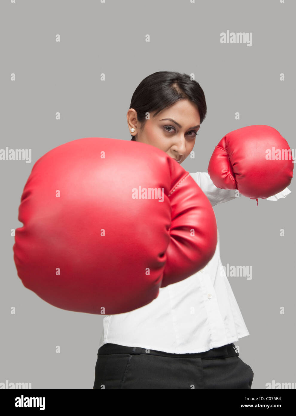 Businesswoman punching with boxing gloves Stock Photo - Alamy