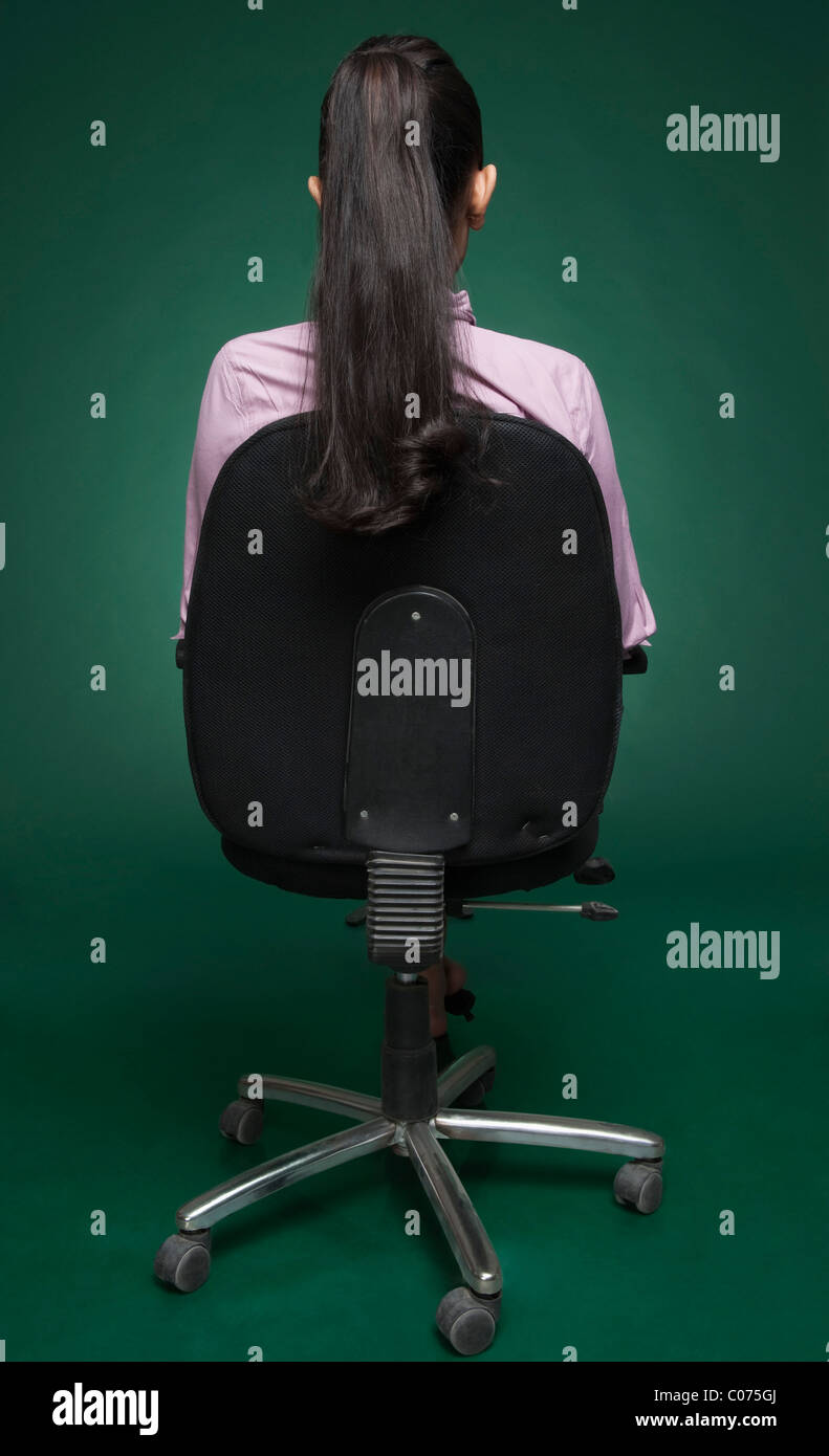 Rear view of a businesswoman sitting on a chair Stock Photo - Alamy