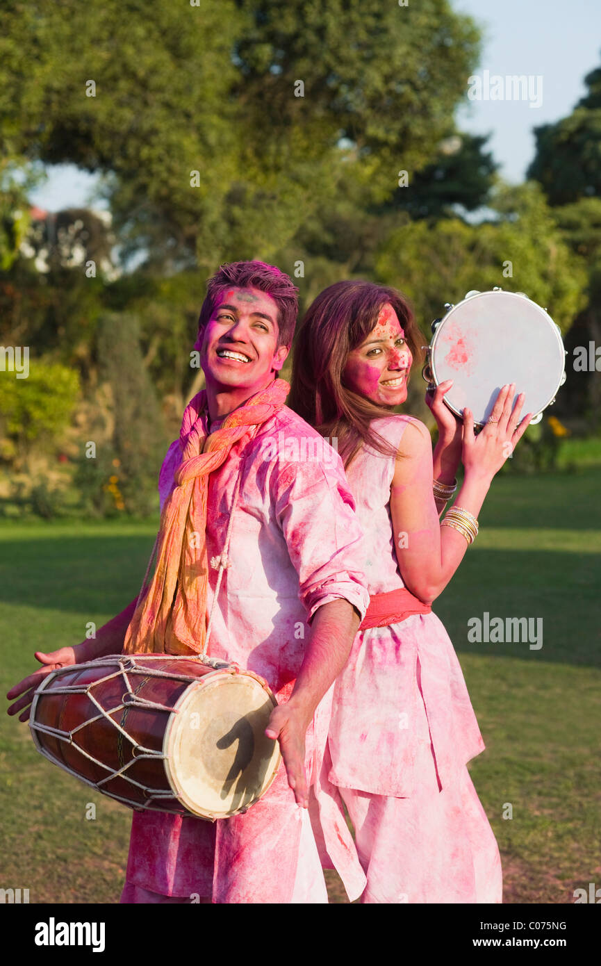 Couple celebrating Holi with musical instruments in a garden Stock ...