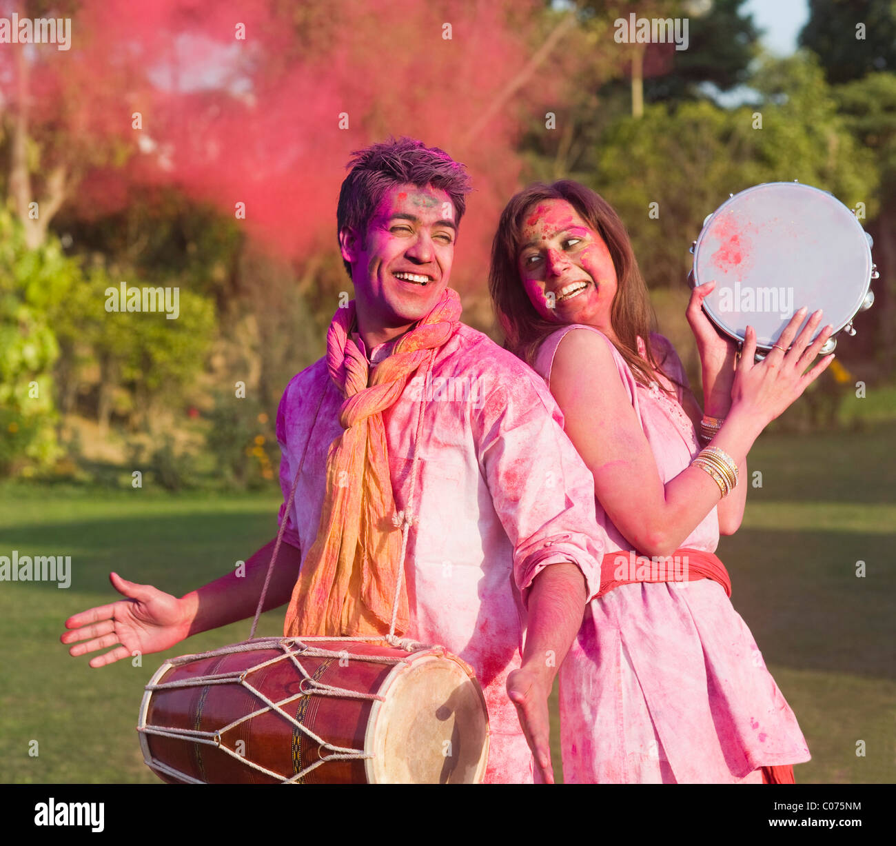 Couple celebrating Holi with musical instruments in a garden Stock ...