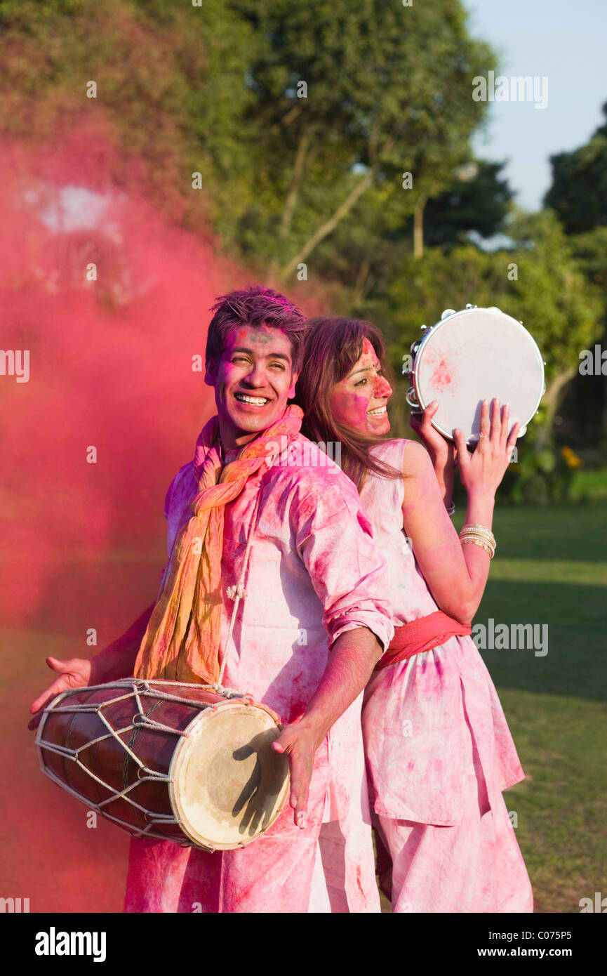 Couple celebrating Holi with musical instruments in a garden Stock ...