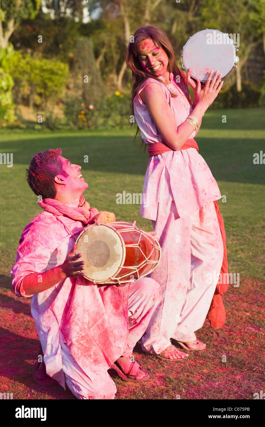 Couple celebrating Holi with musical instruments in a garden Stock ...