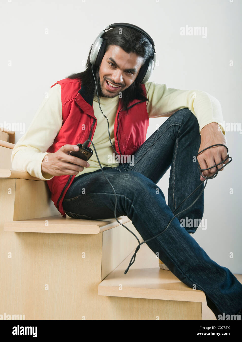 Man listening to an MP3 player on a staircase Stock Photo - Alamy