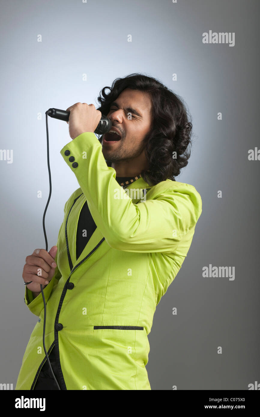 Man singing into a microphone Stock Photo - Alamy