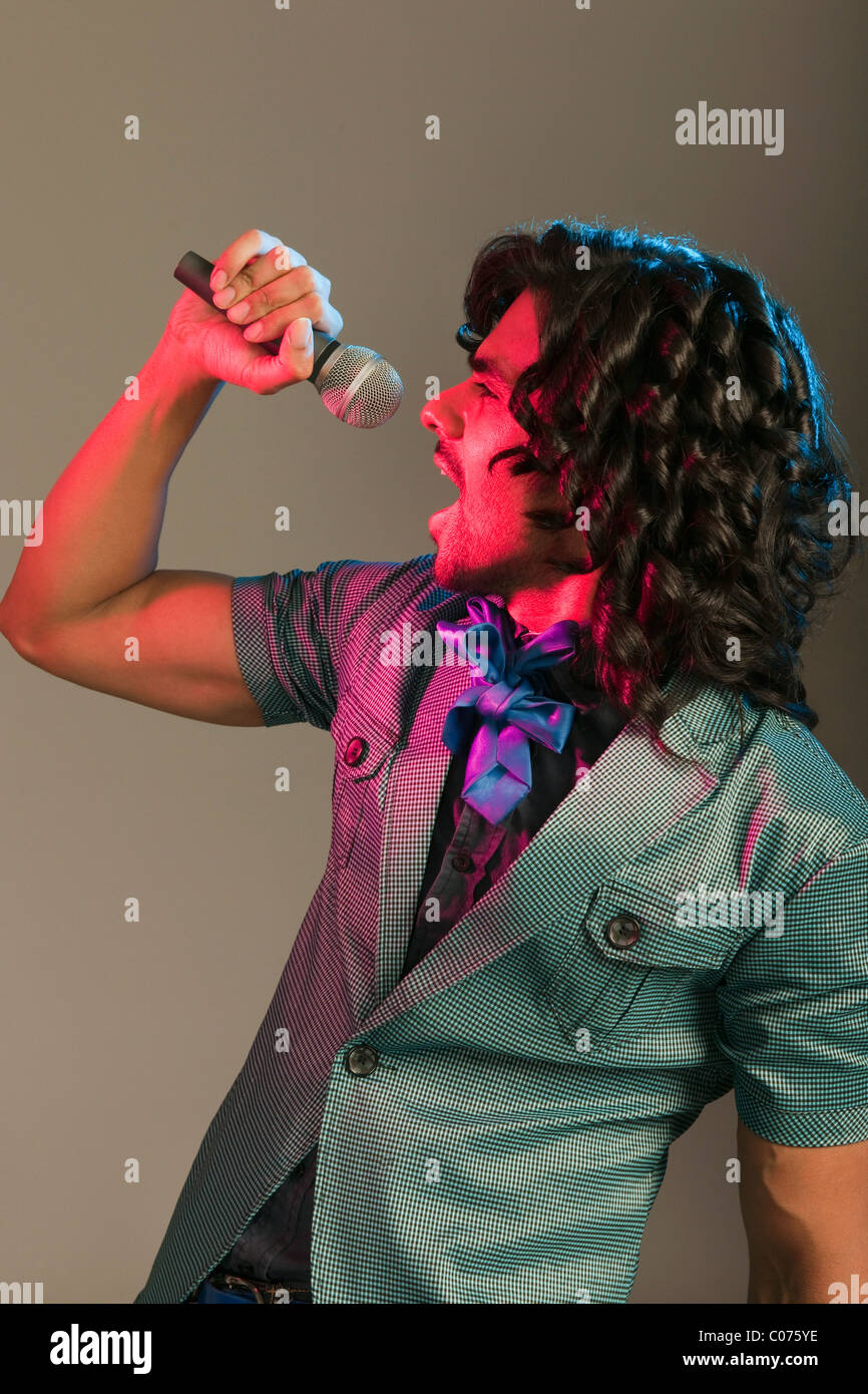 Man singing into a microphone Stock Photo - Alamy