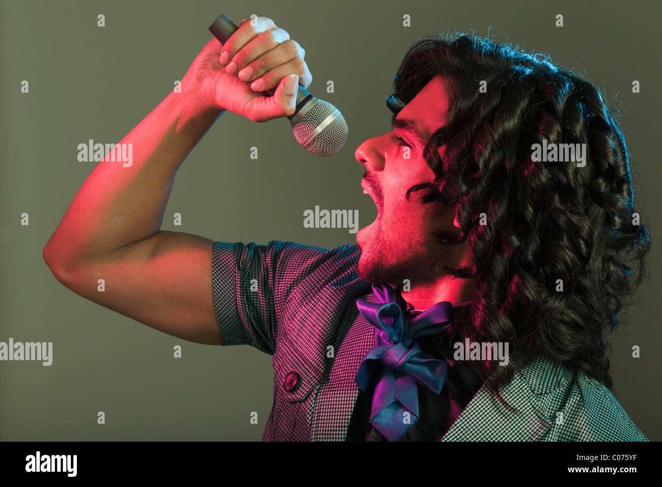 Man singing into a microphone Stock Photo - Alamy