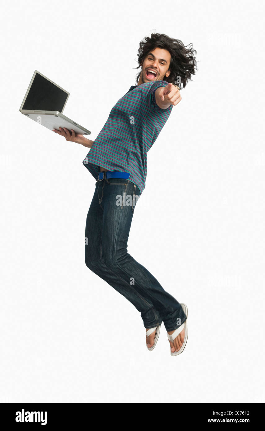 Man jumping while using a laptop Stock Photo - Alamy