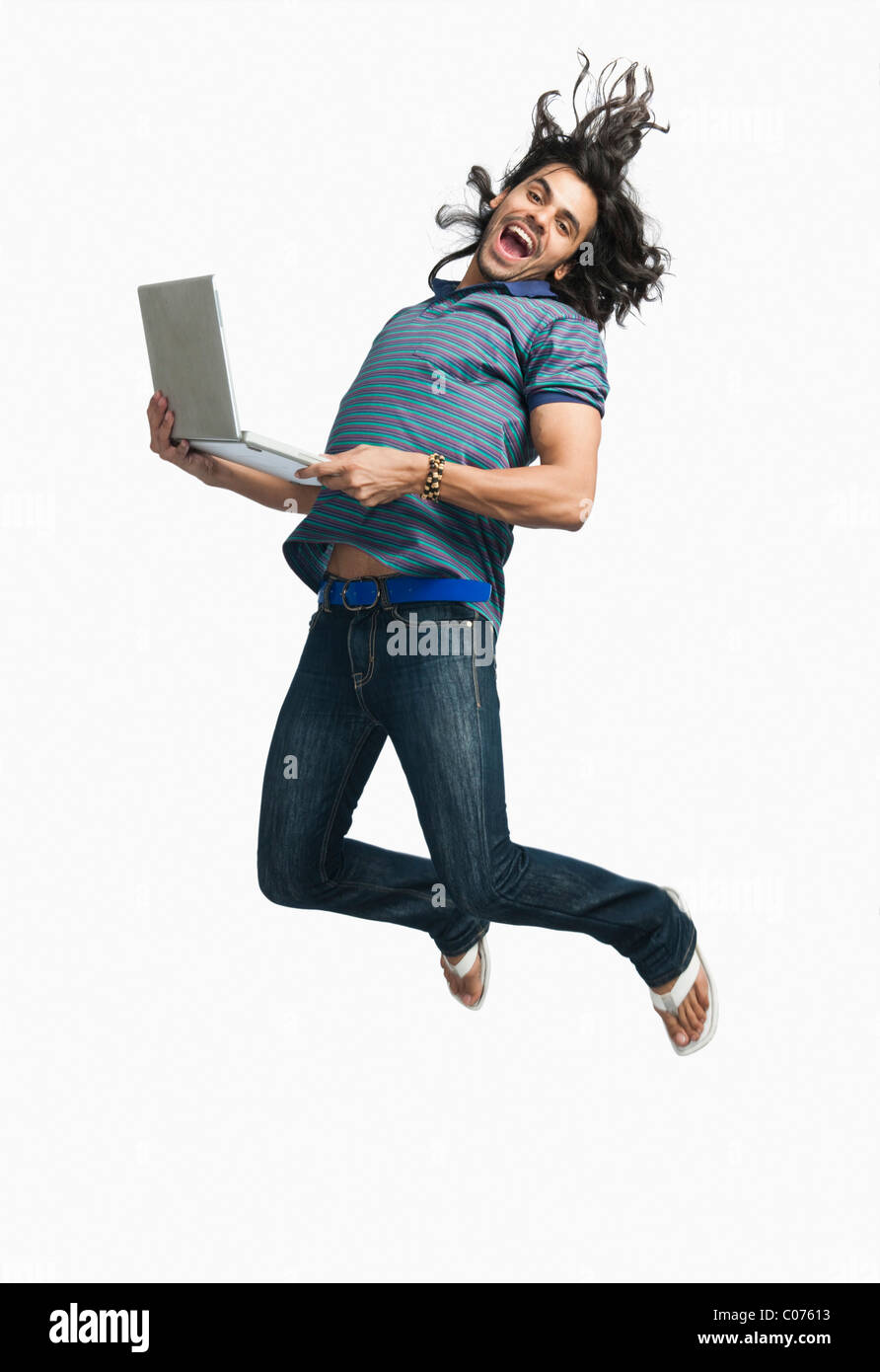 Man jumping while using a laptop Stock Photo - Alamy