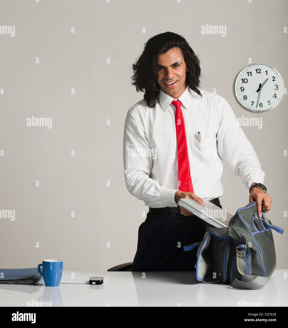 Businessman preparing to leave the office Stock Photo - Alamy