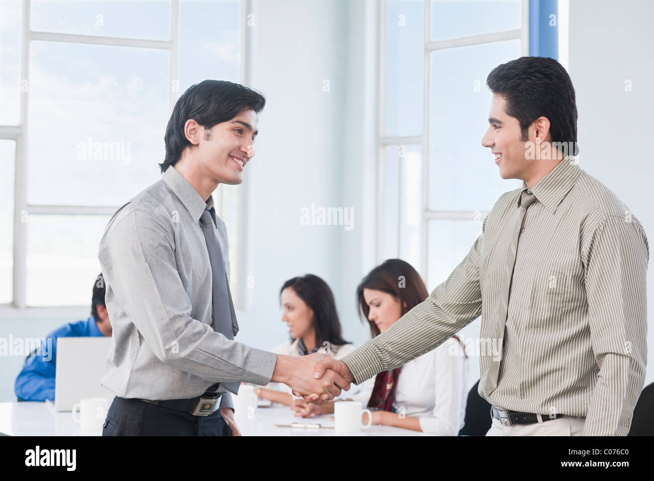 Two businessmen shaking hands in a meeting Stock Photo - Alamy