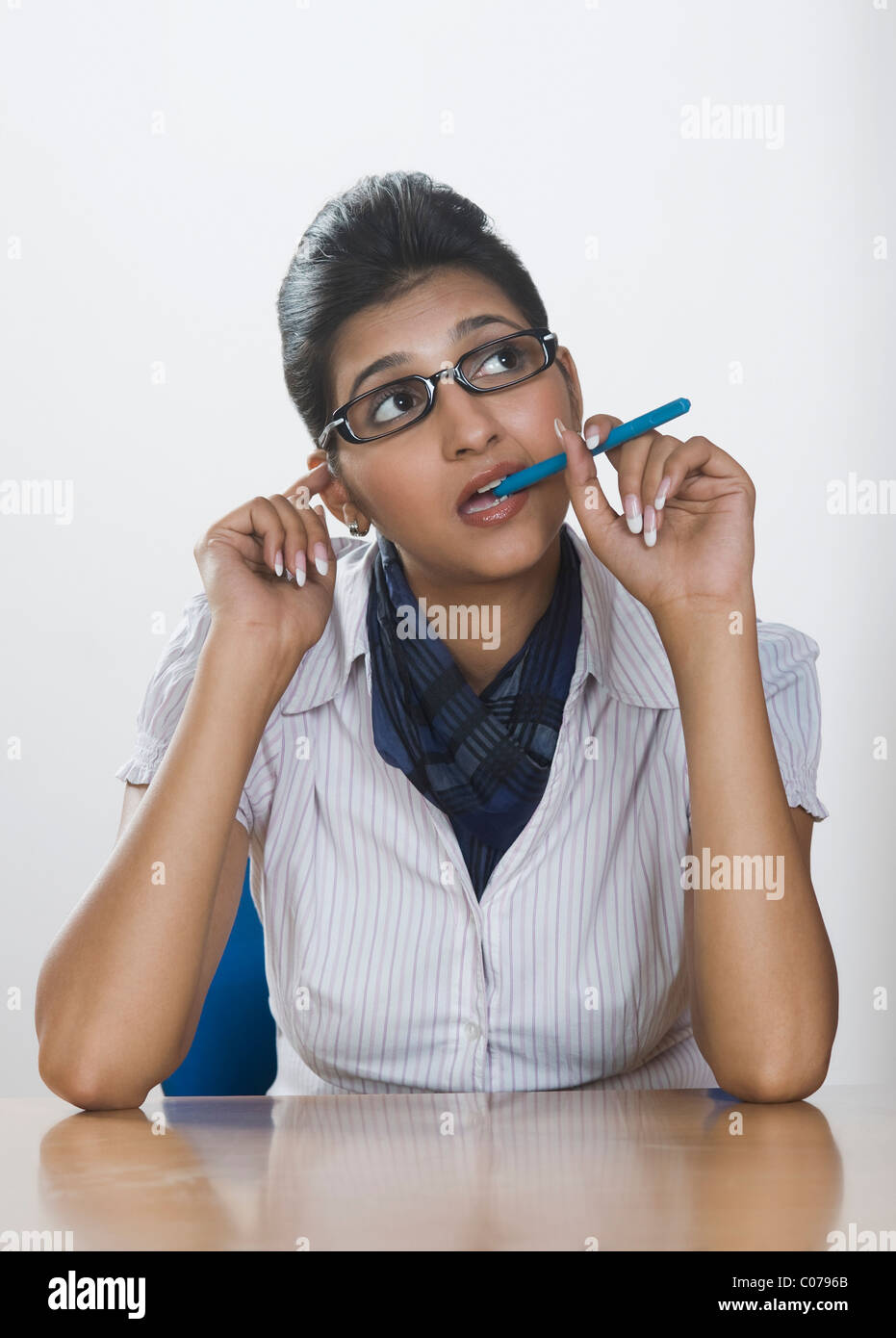 Young woman biting pen hi-res stock photography and images - Alamy