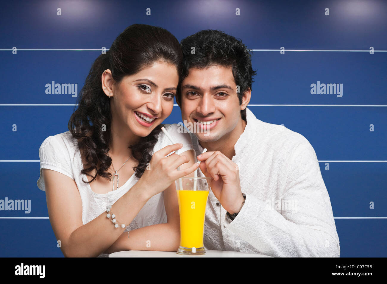 Couple sharing juice from a glass Stock Photo - Alamy