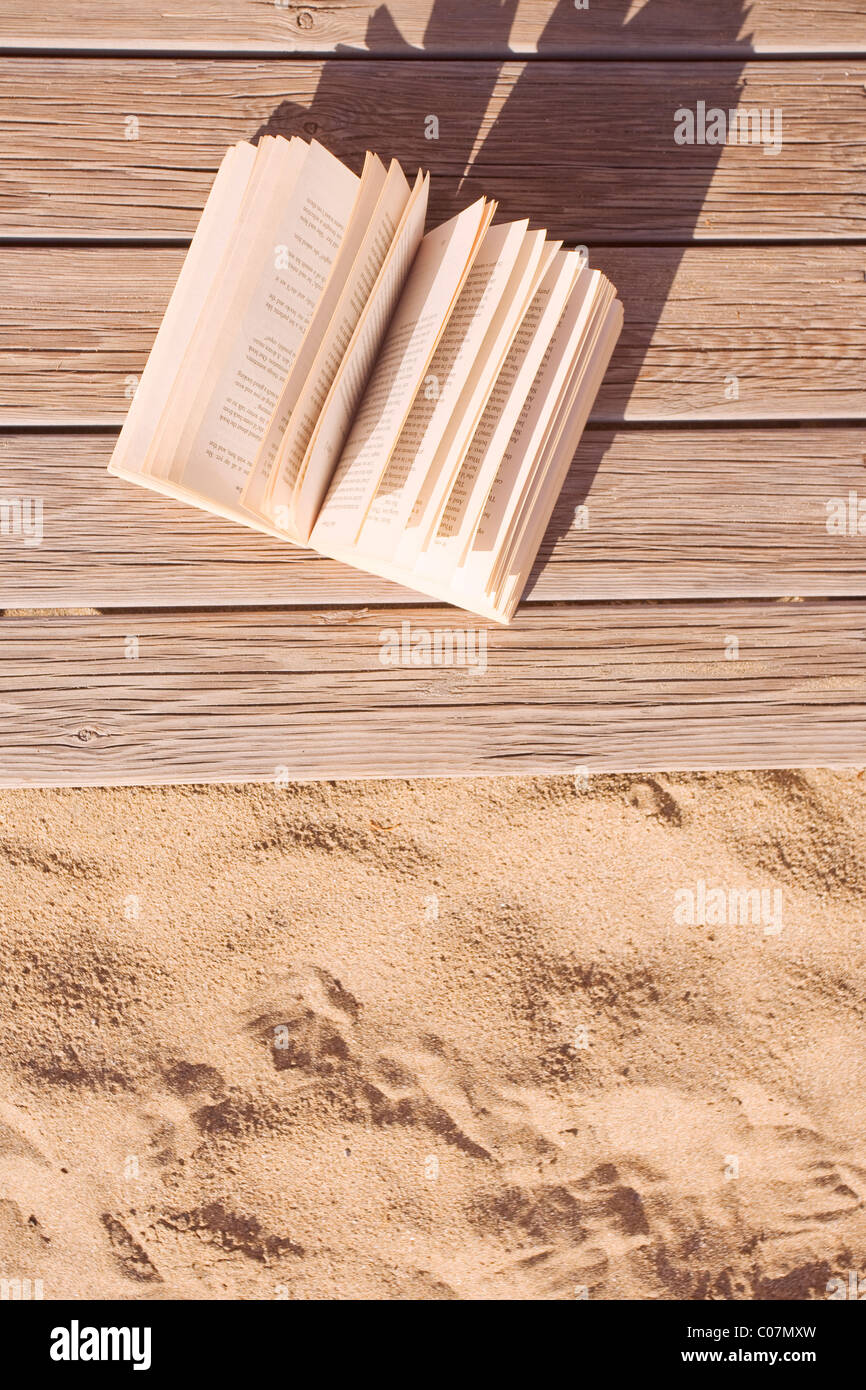 Open book on a boardwalk at sunset Stock Photo - Alamy