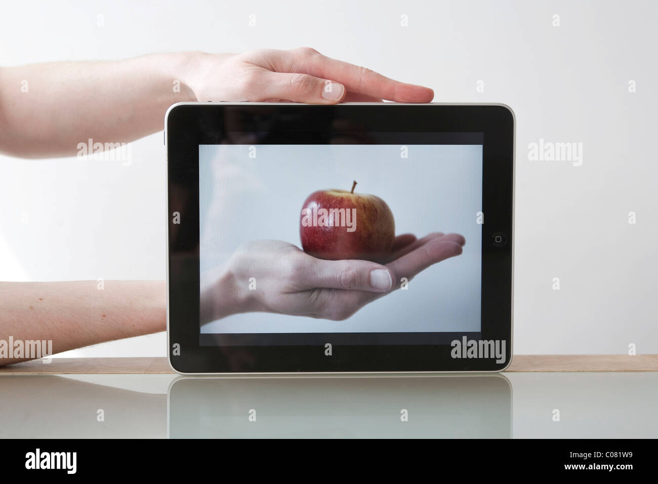 IPad, hand with an apple Stock Photo - Alamy
