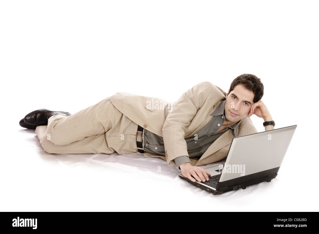 Businessman lying down with laptop Stock Photo - Alamy