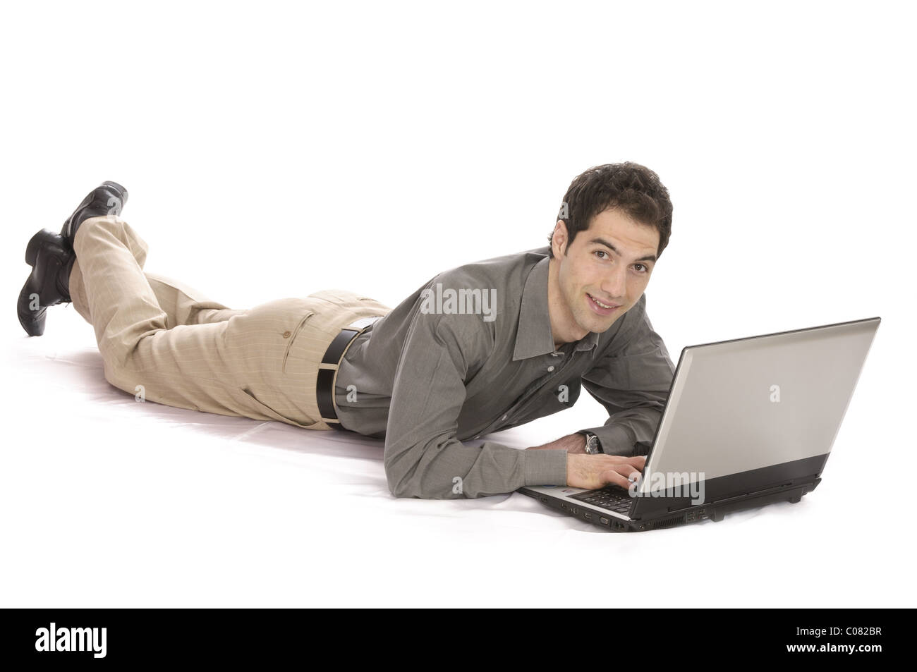 Businessman lying down with laptop Stock Photo - Alamy