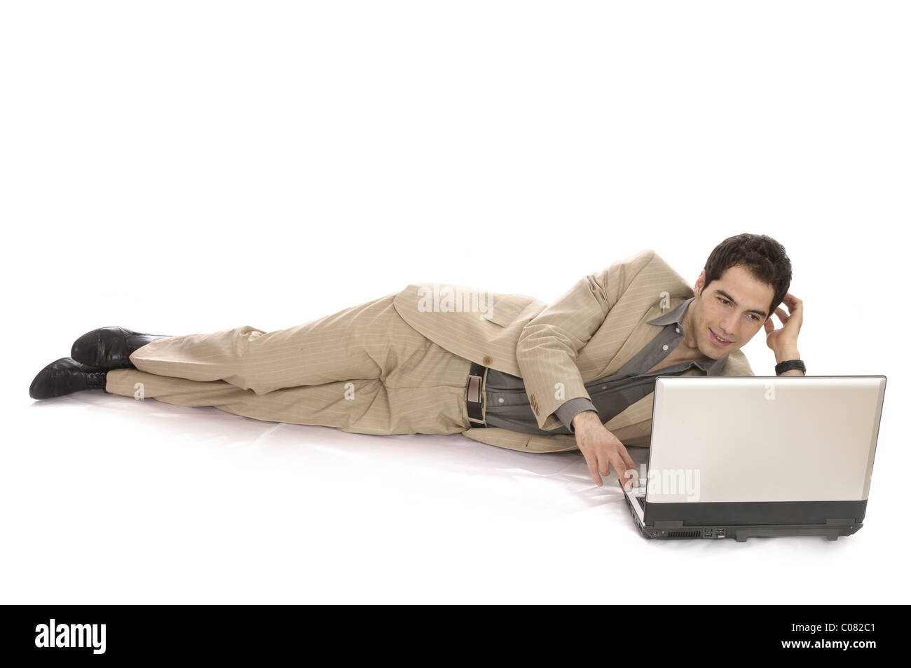 Businessman lying down with laptop Stock Photo - Alamy