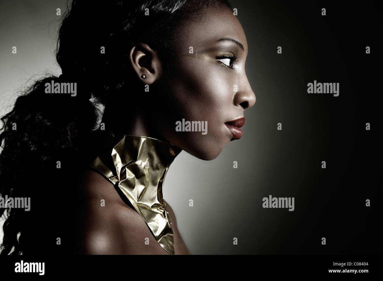 Side portrait of a young dark-skinned woman with a golden collar Stock ...