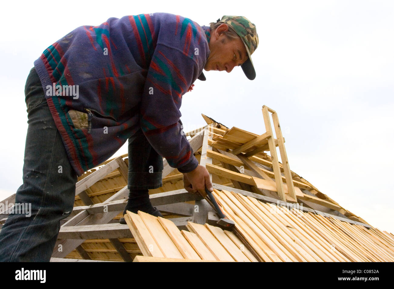 The roofer stacks a wooden tile on a house roof Stock Photo - Alamy