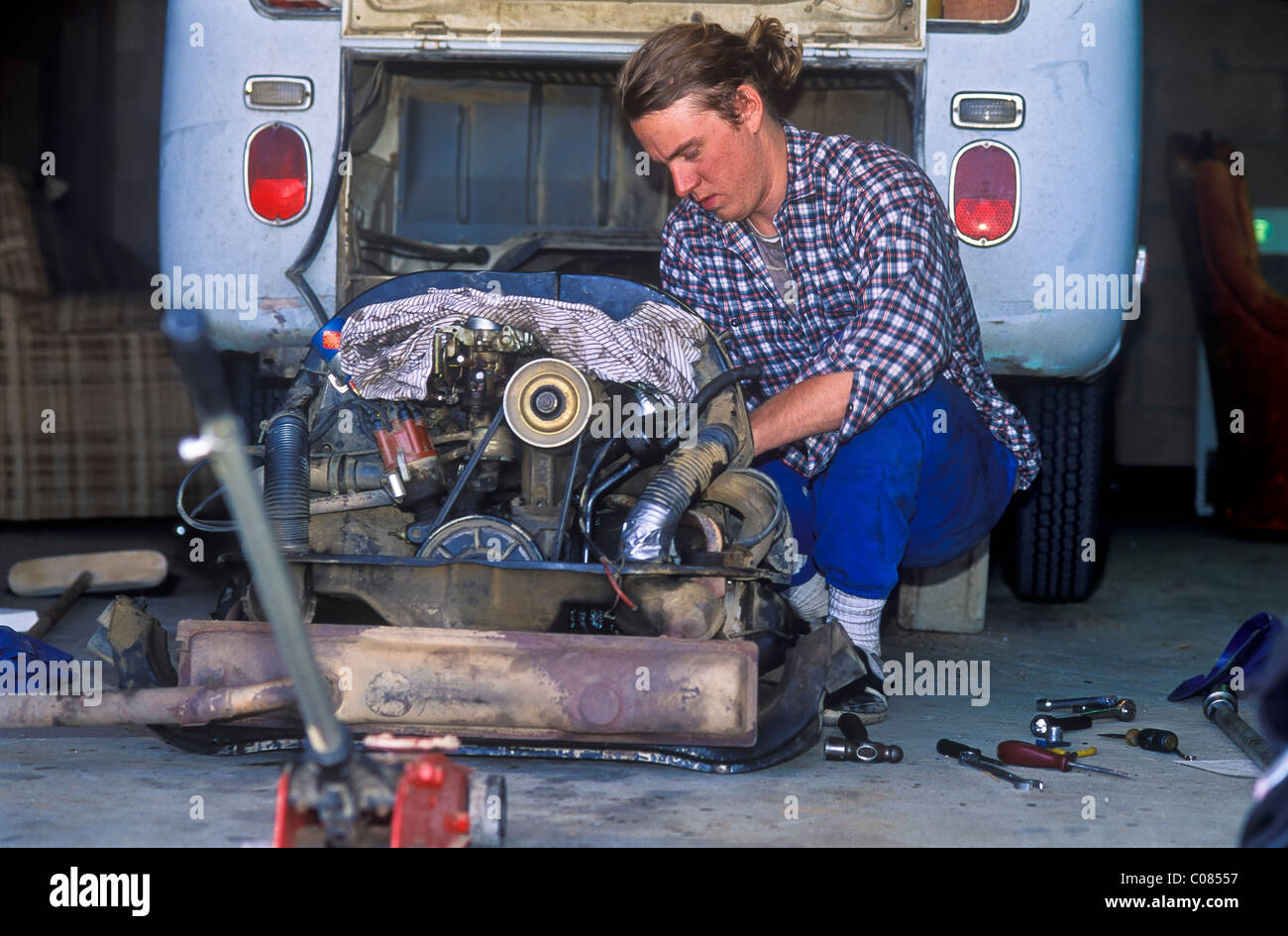 Young man repairing an old van engine in his garage Stock Photo - Alamy