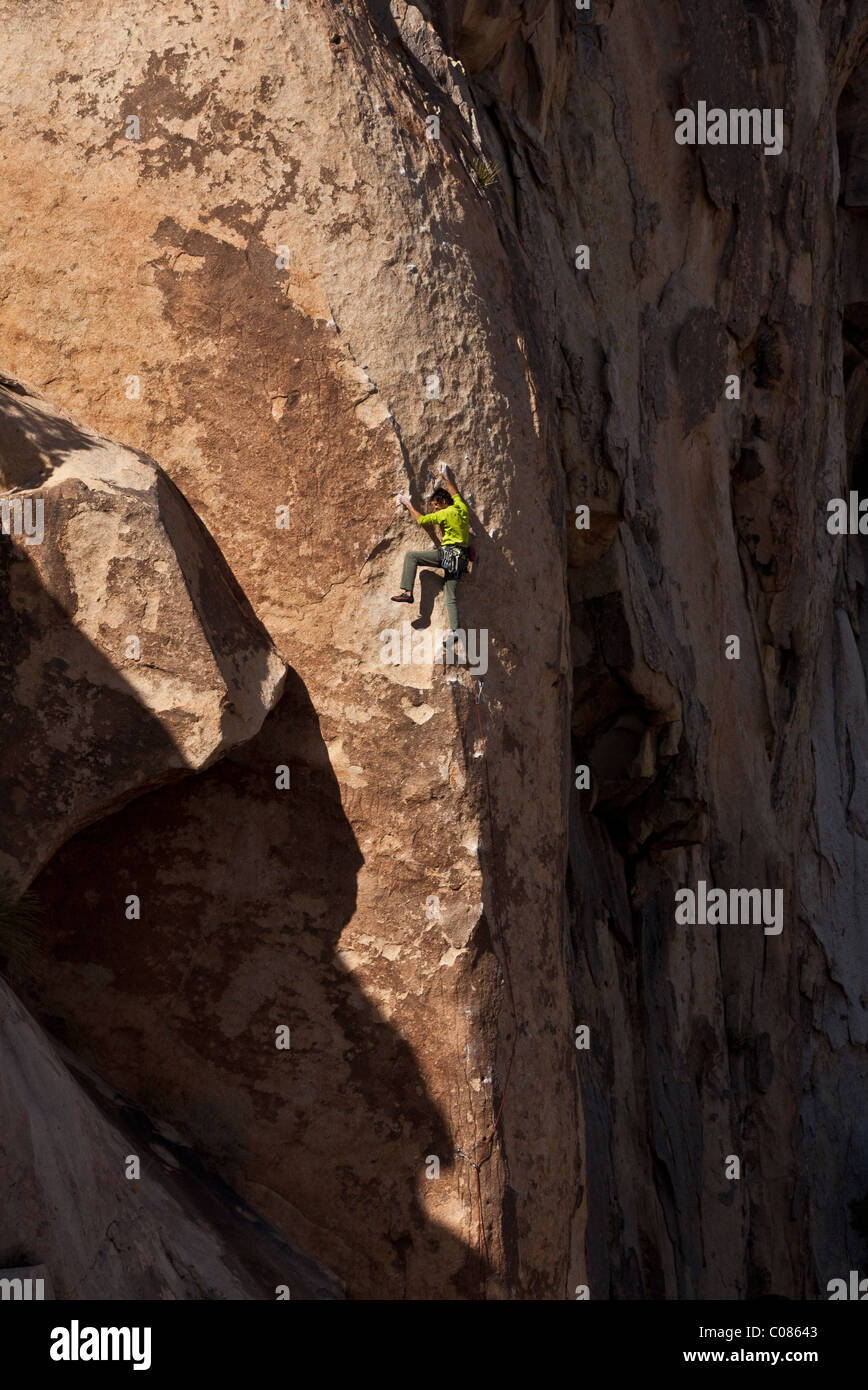 Rock climber struggles for his next grip on a overhanging cliff Stock ...