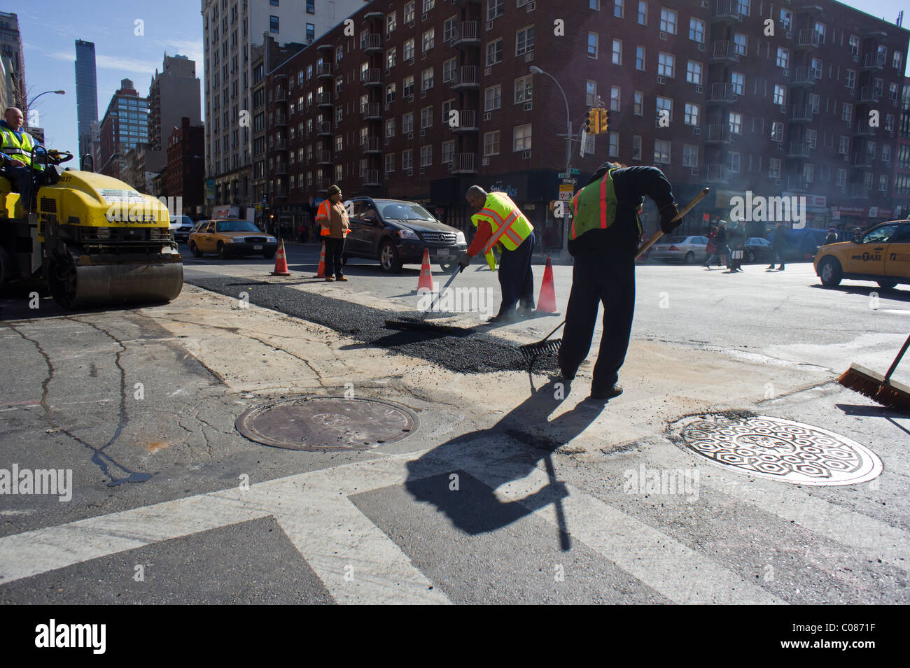 Workers repair a road cut in the New York neighborhood of Chelsea on ...