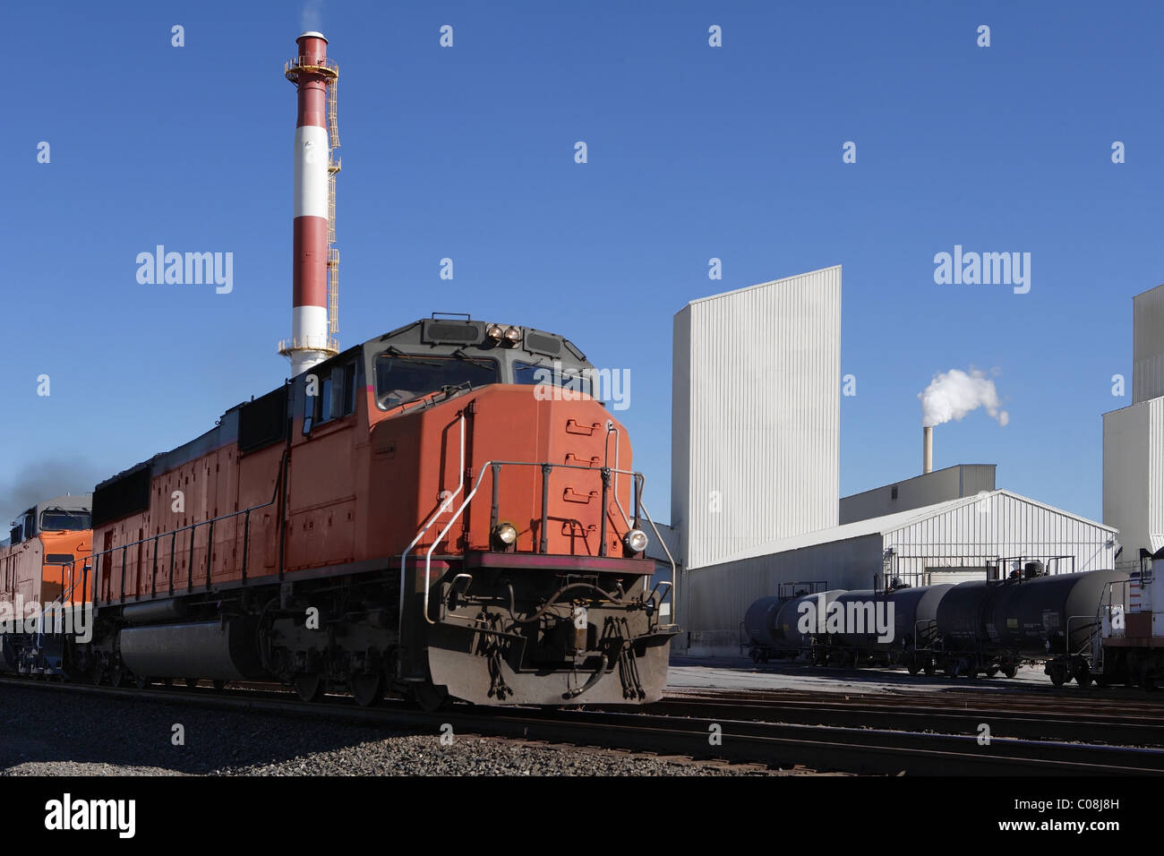 Railroad locomotives passing an industrial plant Stock Photo - Alamy
