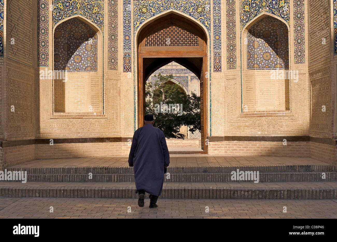 Uzbeki man walking towards the entranceway of the Kalon Mosque, Bukhara ...