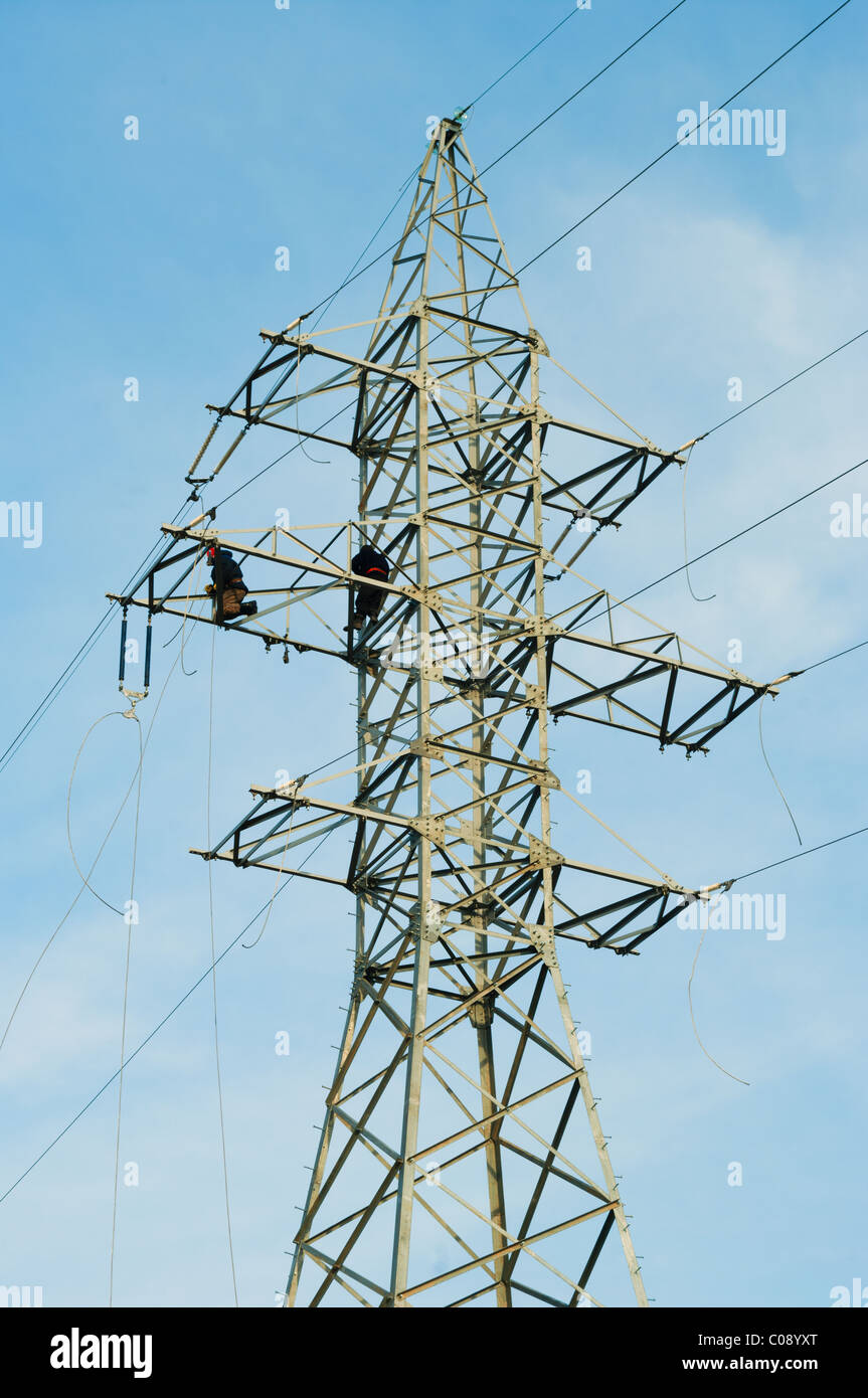 Power linemen at work up on a pylon tower Stock Photo - Alamy