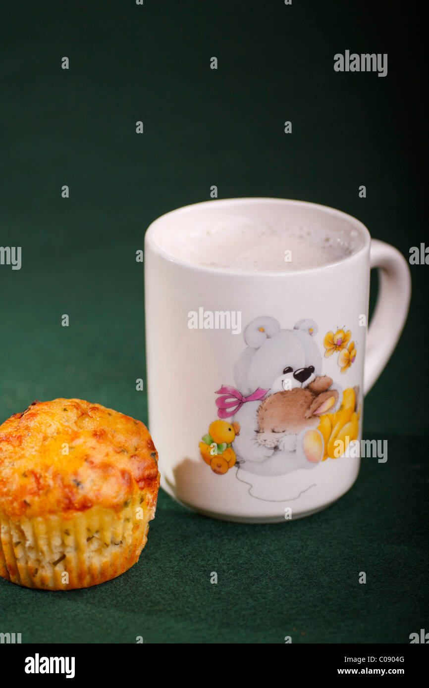 Hot frothy beverage in a mug featuring a teddy bear and a muffin ...