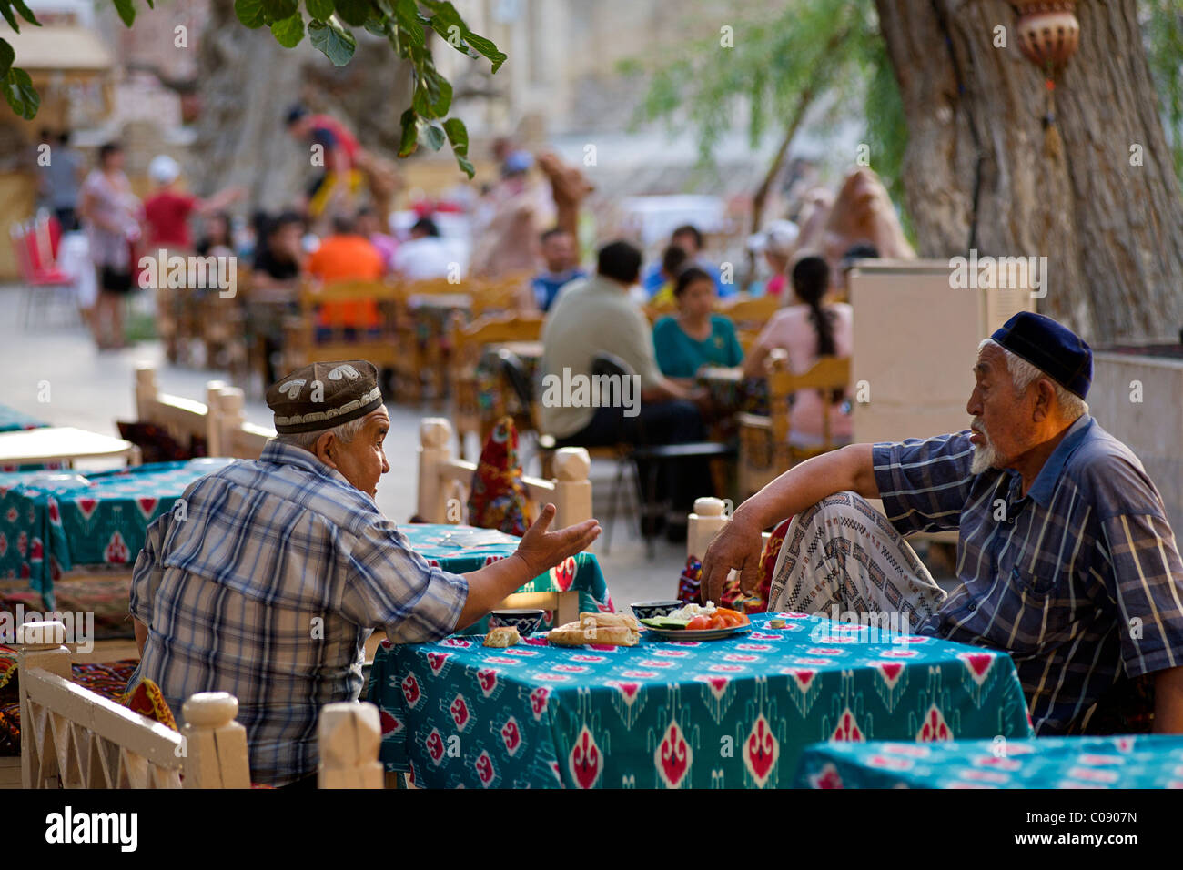 Uzbeki men eating at a table and talking. Lyabi Hauz, Bukhara ...