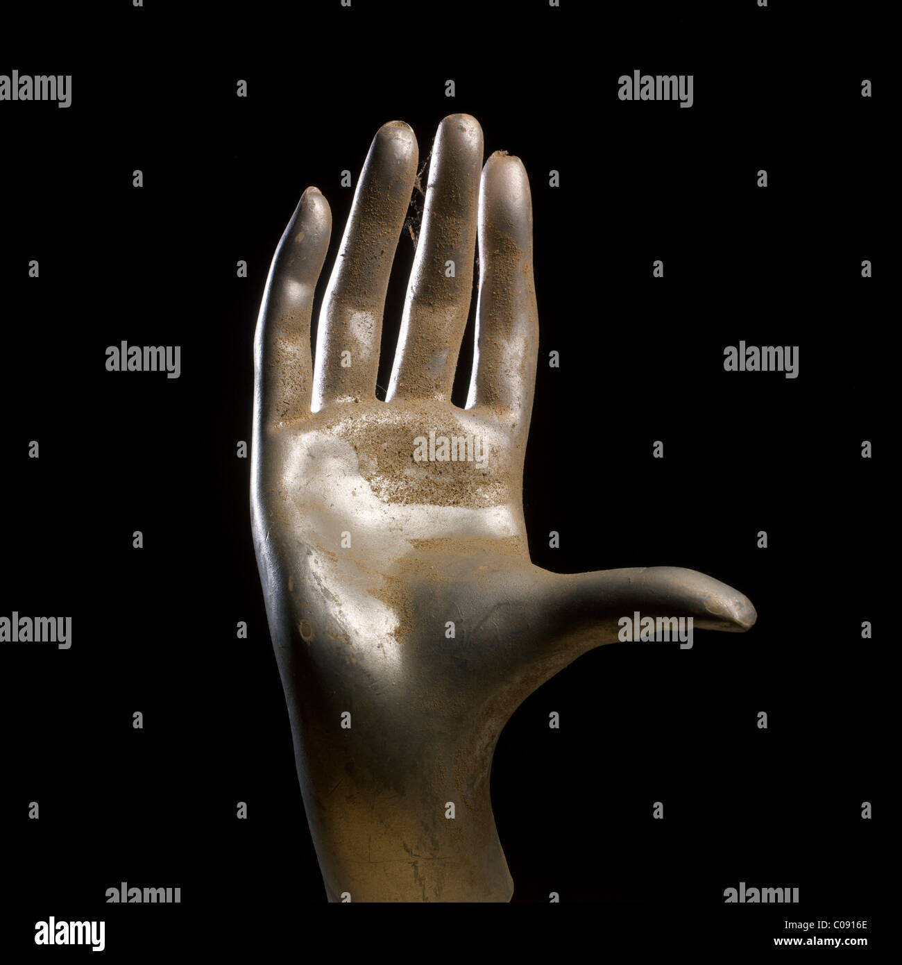 Detailed depiction of a metallic hand sculpture against a black ...