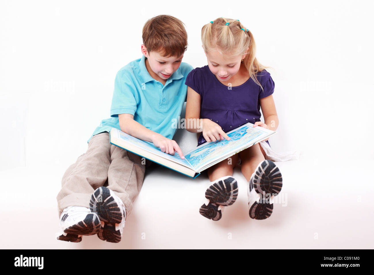 School kids reading a book Stock Photo - Alamy