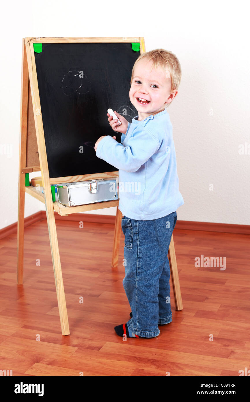 Adorable boy playing with chalkboard Stock Photo - Alamy
