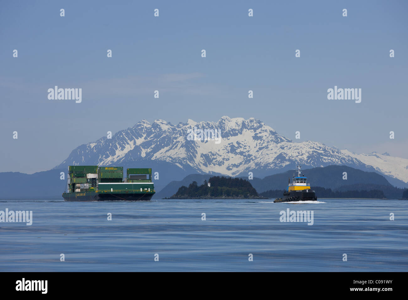 A tug pulling a barge cruises through the Inside Passage on its way ...