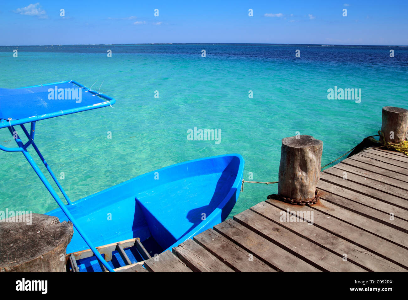 blue boat in wooden tropical pier in Caribbean beach Stock Photo - Alamy