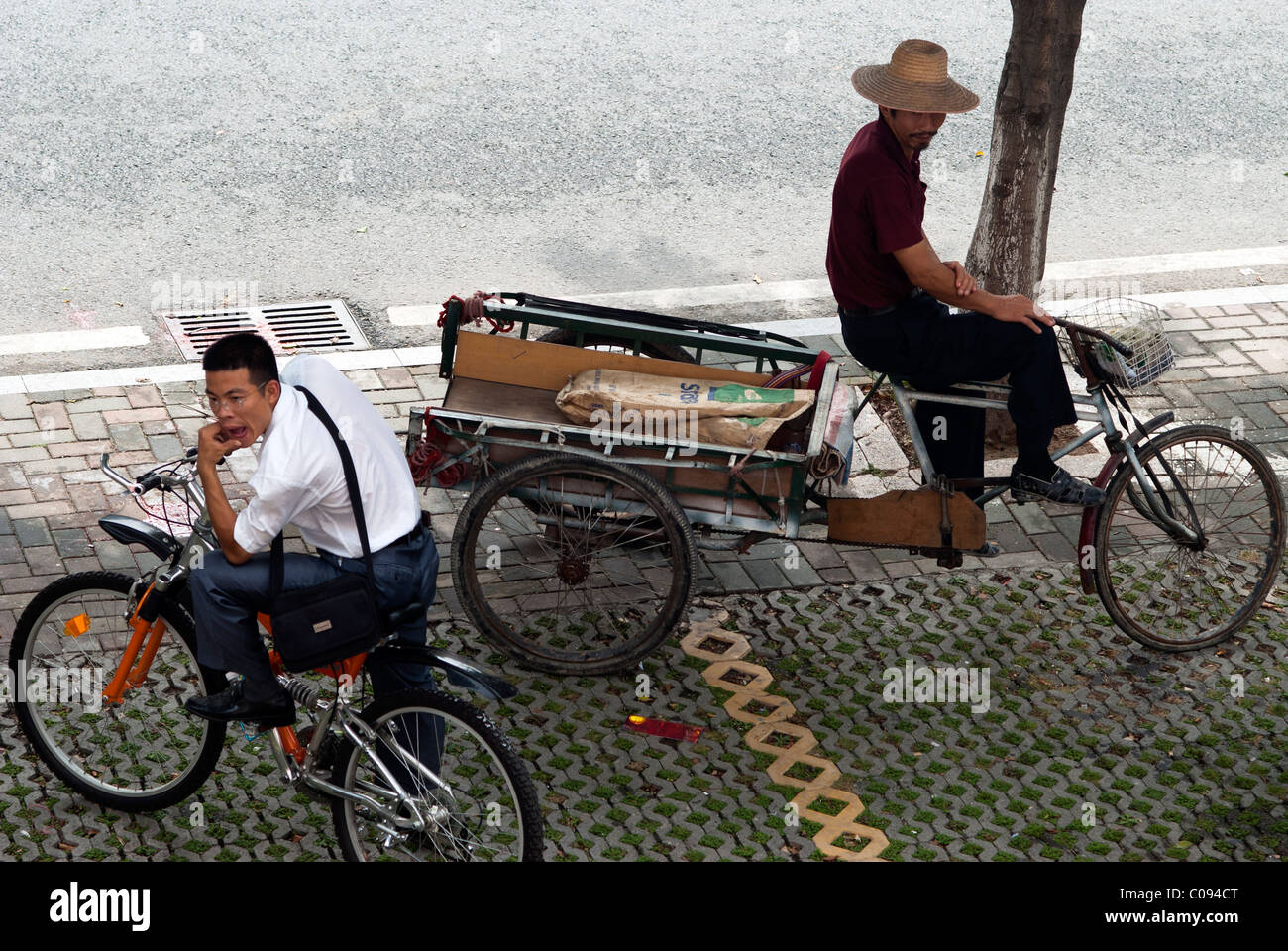 two Chinese man on bicycles looking at something Stock Photo - Alamy