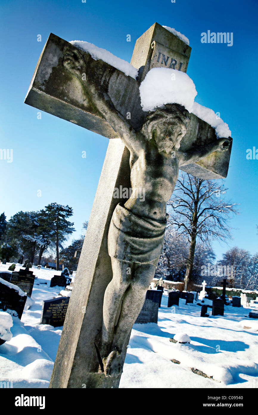 Crucifix headstone in snow covered cemetery Stock Photo - Alamy