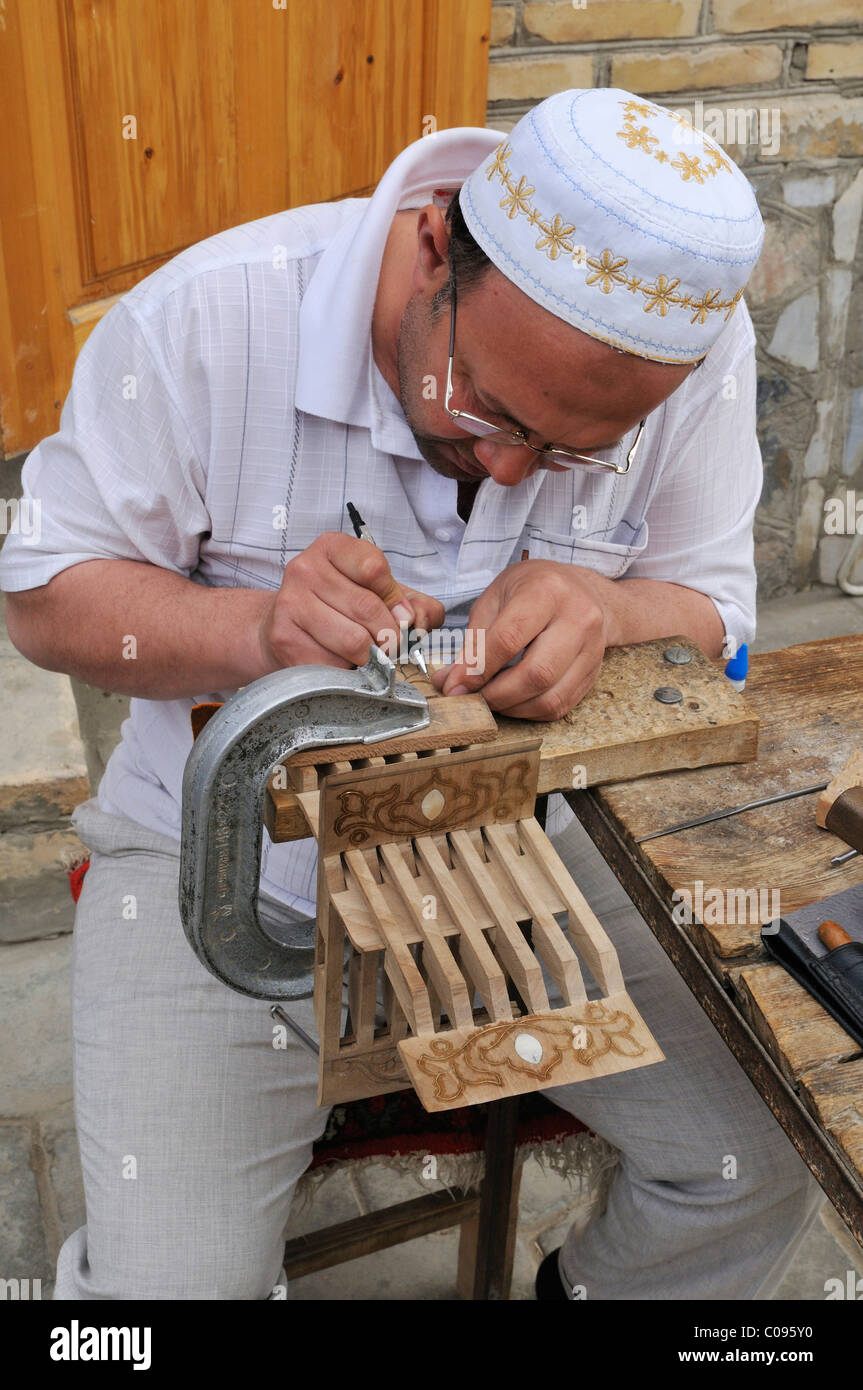 Uzbek man carving a Quran, Qur´an holder, historic town of Bukhara ...