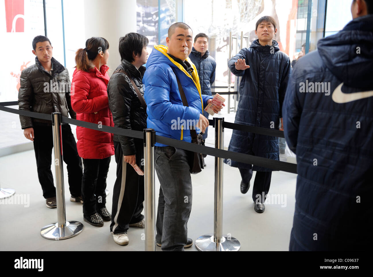 Chinese young people with cash in hands queue to buy iPhone 4 in the ...