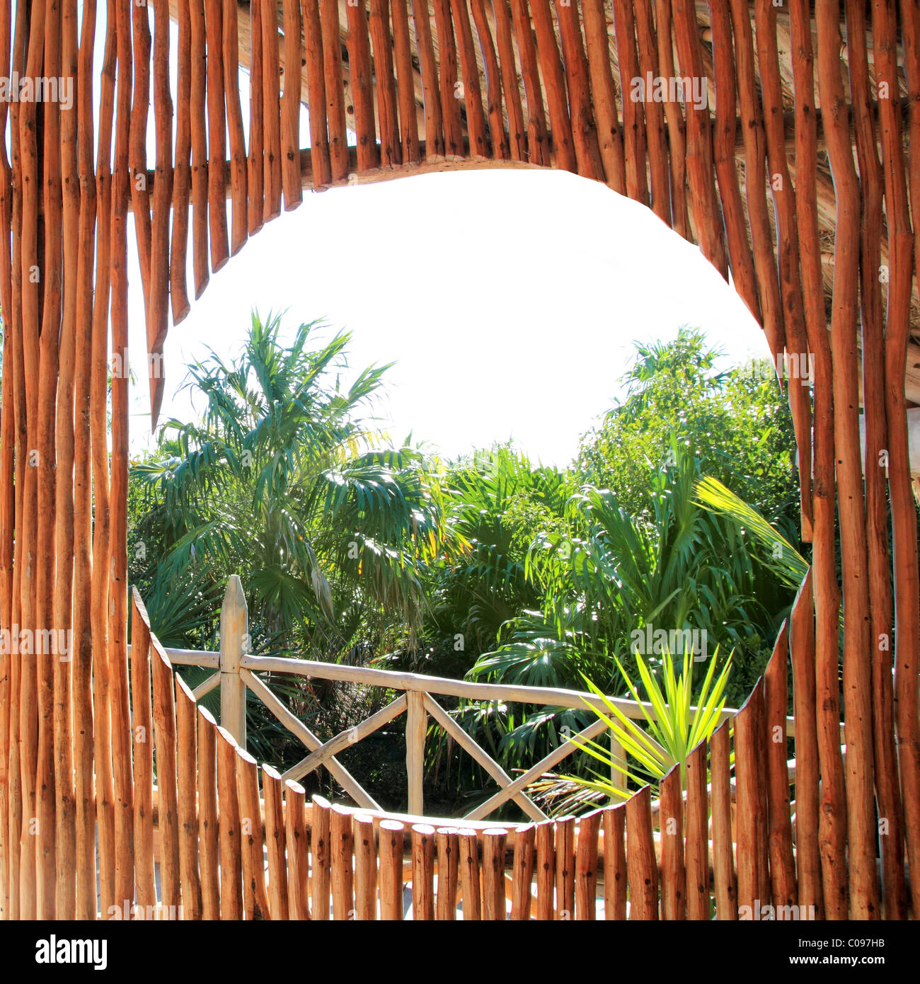 circle window in wooden sticks cabin with tropical Jungle background ...