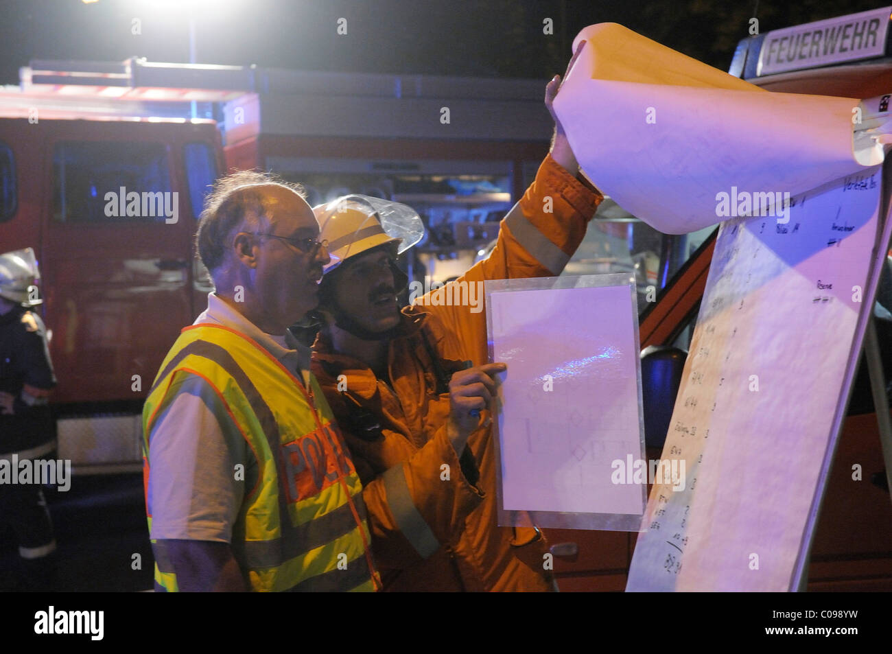 Firefighter briefing with a policeman, firefighting operation ...