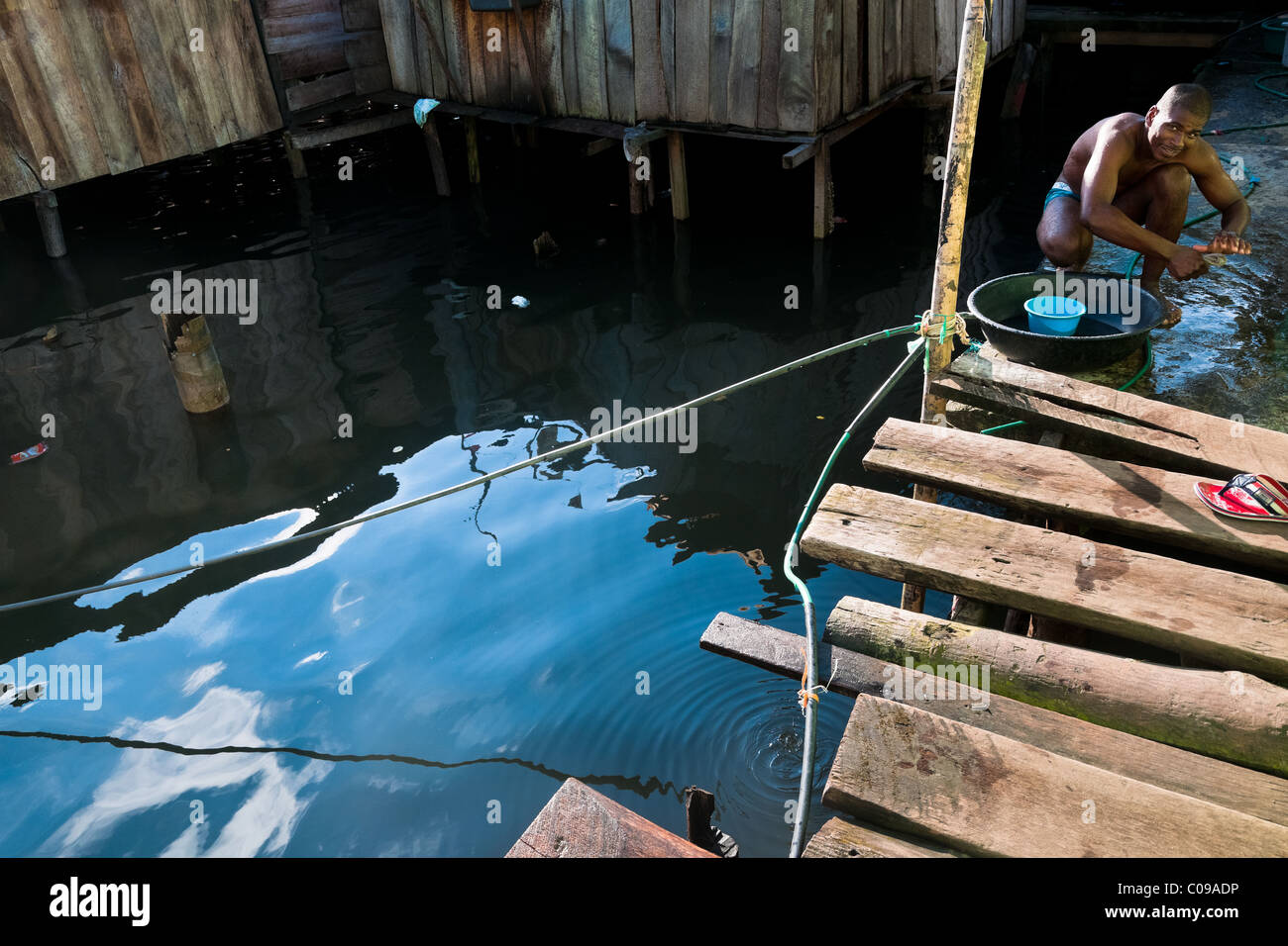A Colombian shellfish picker wash the mud off his clothes after return ...