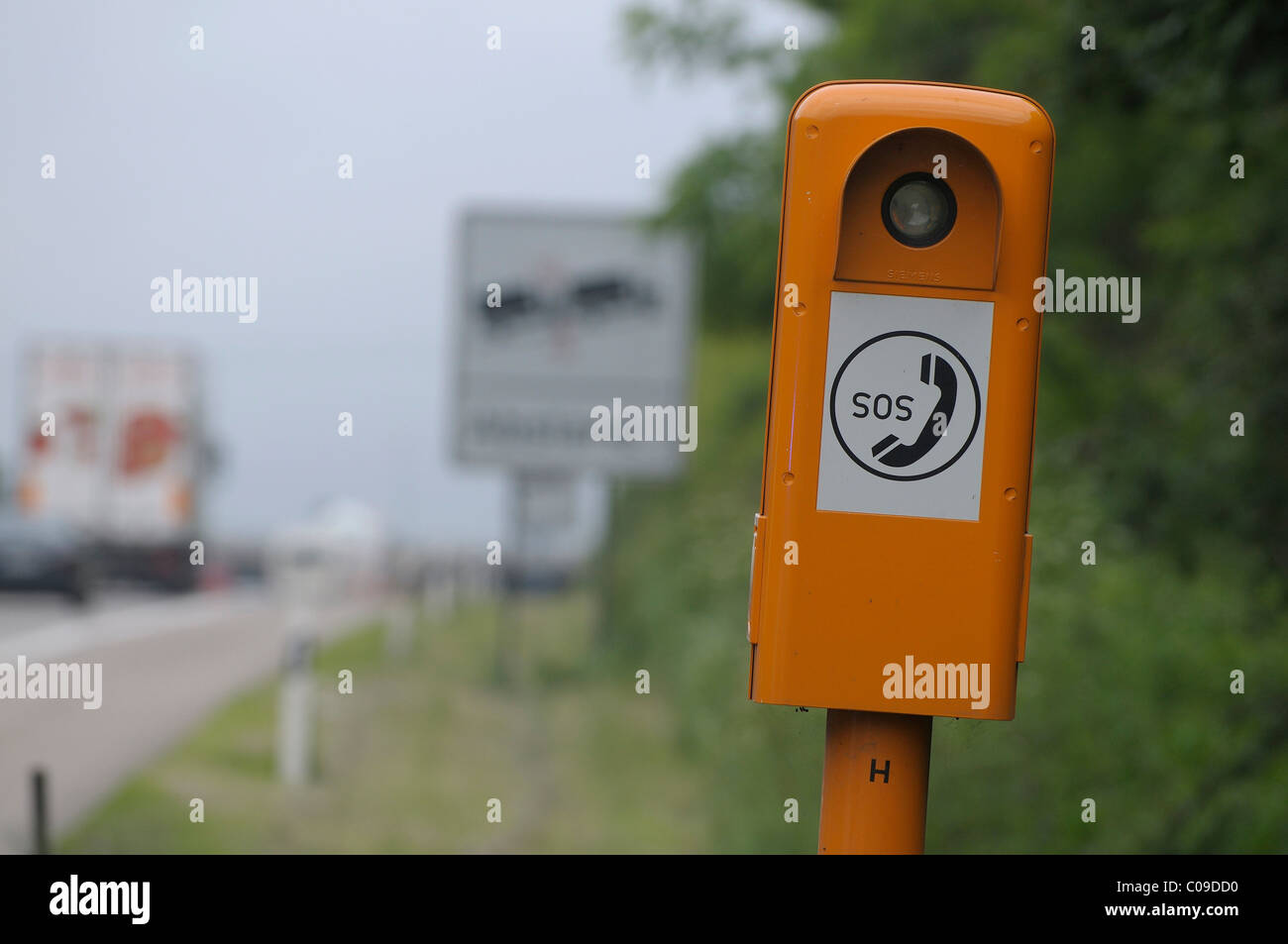 Emergency phone on the A8 motorway, in the rear a sign warning against ...