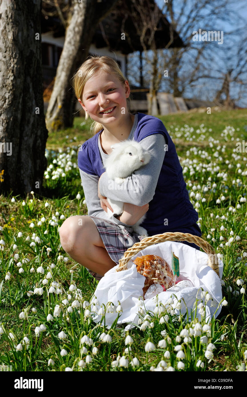 Girl holding a rabbit in her arms, with an Easter basket, Easter bunny ...