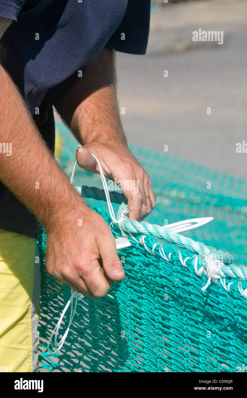 Fisherman mending his net Stock Photo - Alamy