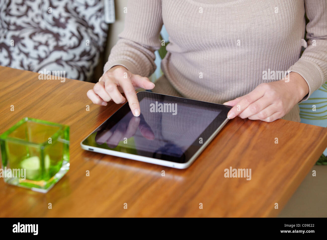 Young woman using an iPad tablet computer at a cafe table Stock Photo ...