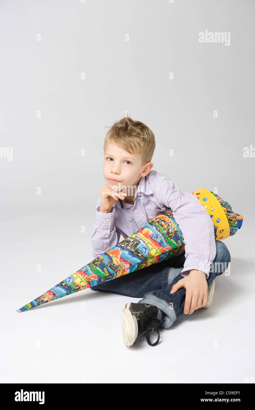Boy holding a large cornet of cardboard filled with sweets and little ...