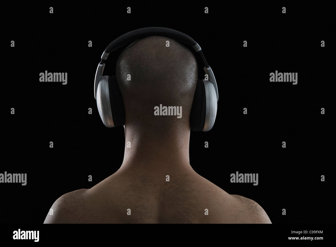 Rear view of a man listening to headphones Stock Photo - Alamy
