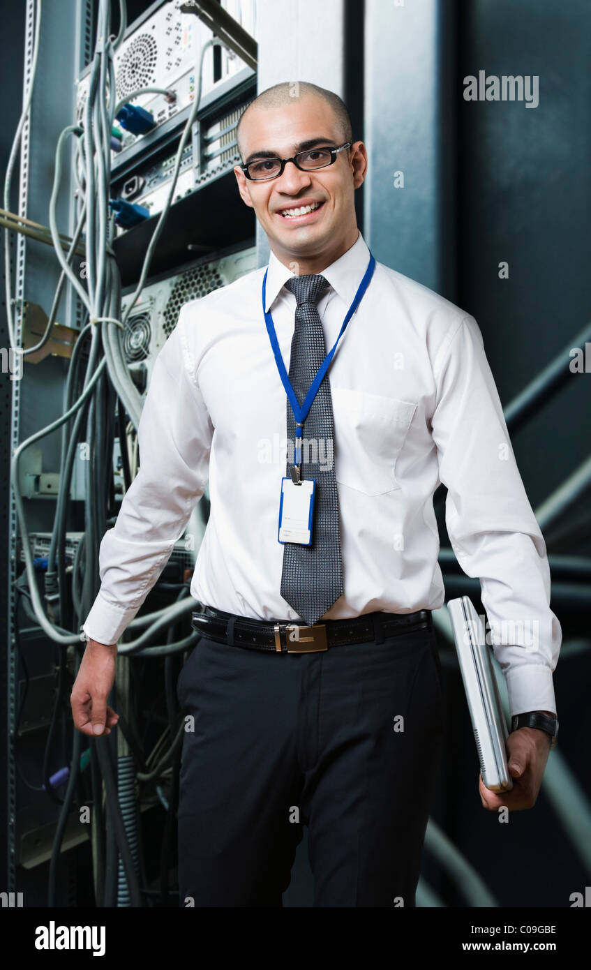 Portrait of a technician smiling in a server room Stock Photo - Alamy